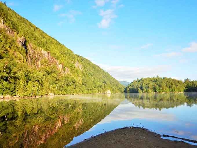 Chapel Pond mirrors the mountains so perfectly you'll spend ten minutes deciding which reflection is the real one.