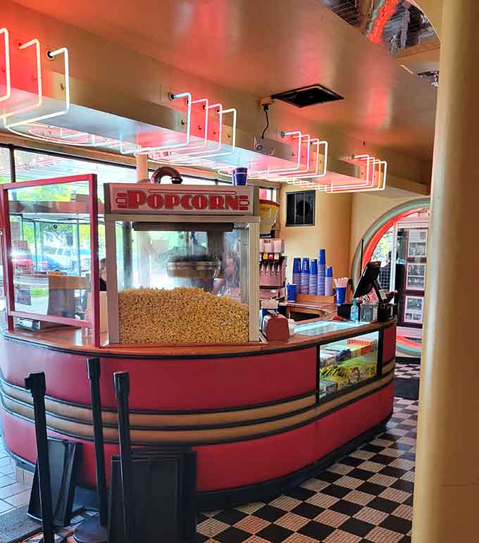 The curved red concession counter with its glowing neon overhead makes even popcorn feel glamorous.