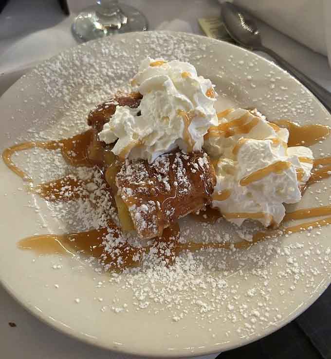 Apple strudel crowned with whipped cream and caramel drizzle. Dessert this good deserves its own standing ovation.