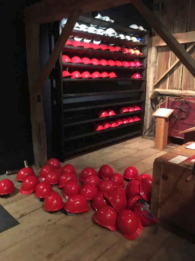 Shelves full of red hard hats waiting patiently, like the world's most historically significant hat rack.
