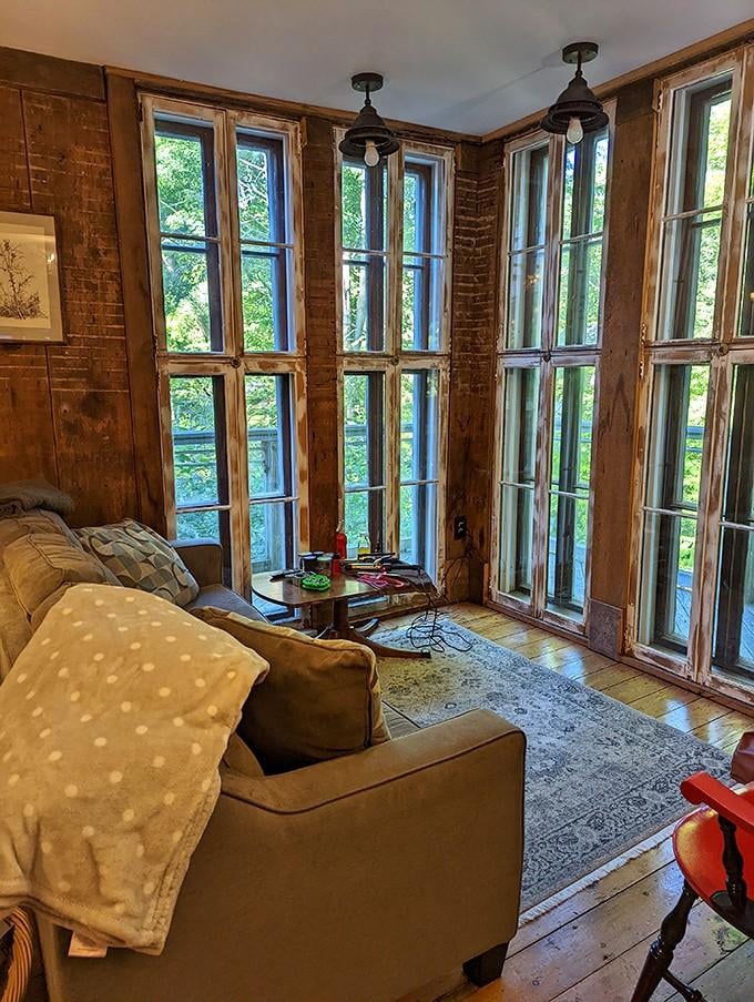 Floor-to-ceiling salvaged windows that frame the trees like nature's own flat screen. No subscription required.