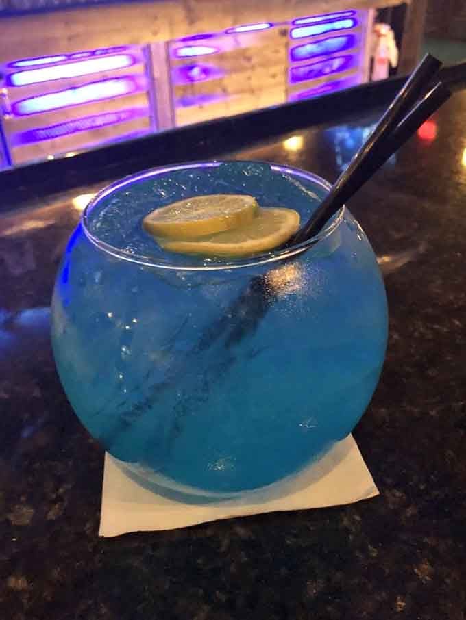 A glowing blue fishbowl cocktail with lemon slices is basically the ocean in a glass, minus the sunburn.