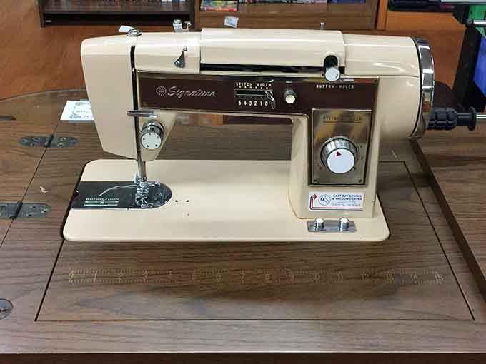 A vintage Signature sewing machine sitting in its original cabinet, looking like it just stepped out of a 1960s catalog.
