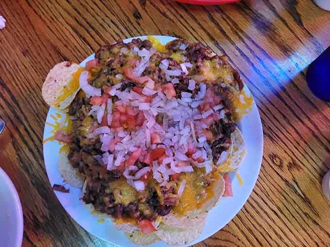 Nachos piled high with smoked meat, melted cheese, tomatoes, and onions. This is what happens when BBQ crashes a party.