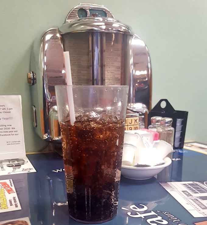An ice-cold drink in a tall glass, sitting next to a chrome jukebox selector, this table has excellent taste.