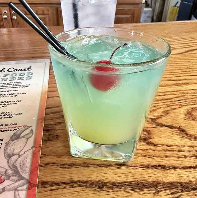 That blue cocktail looks like summer vacation decided to take liquid form and bring a cherry friend along.