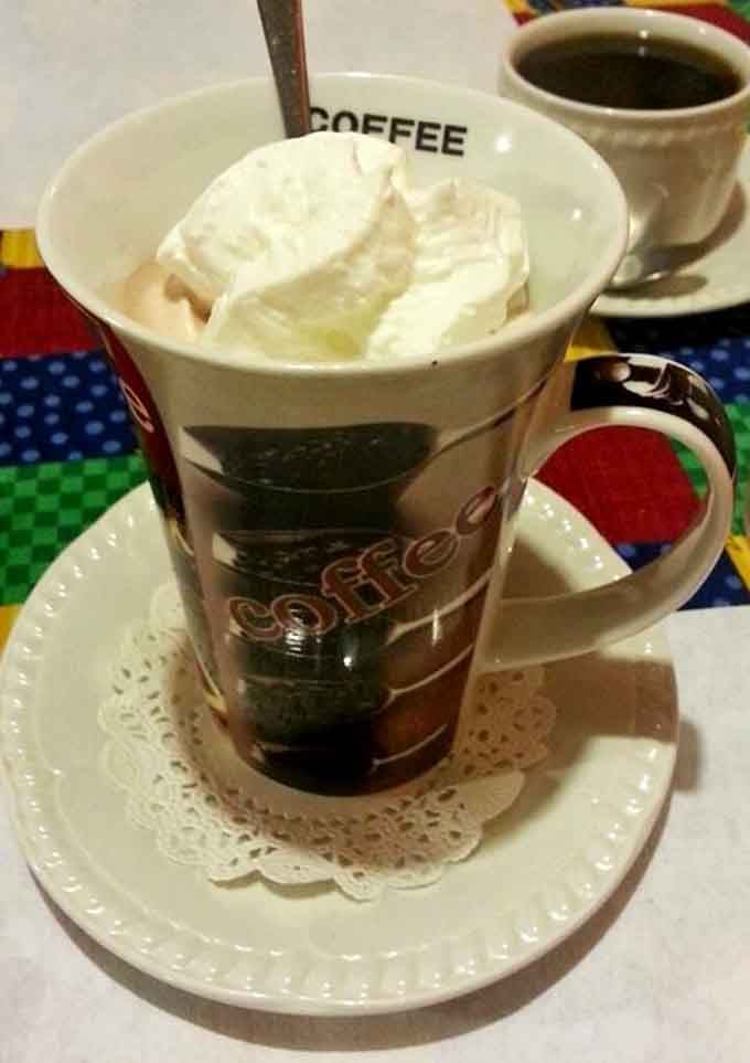 Whipped cream piled high on a warm mug, the kind of coffee moment that makes you slow down and appreciate everything.