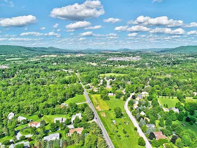 Boalsburg spreads across a sun-drenched valley below, its steeples and rooftops nestled into rolling green hills like a postcard that forgot to leave.