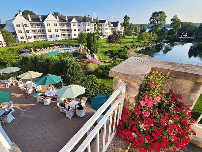 Manicured gardens meet waterfront elegance where geraniums cascade like they're auditioning for a Better Homes spread, and winning.