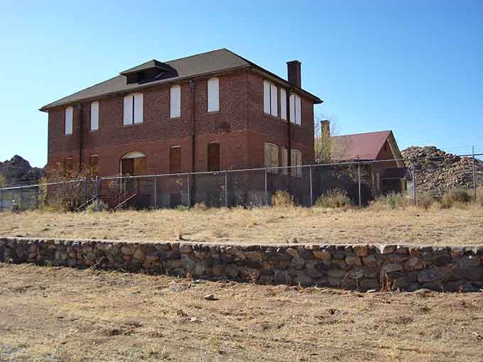That boarded-up brick schoolhouse in Valentine stands behind its chain-link fence like a stern teacher who never quite retired.