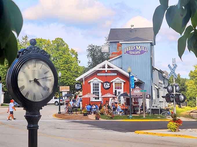That old-fashioned clock stands guard over a scene mixing vintage mill charm with modern visitors seeking authentic small-town magic.