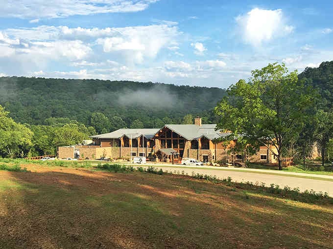 Morning mist rises over rustic lodges where the Ozarks show off their best moody, mysterious side.