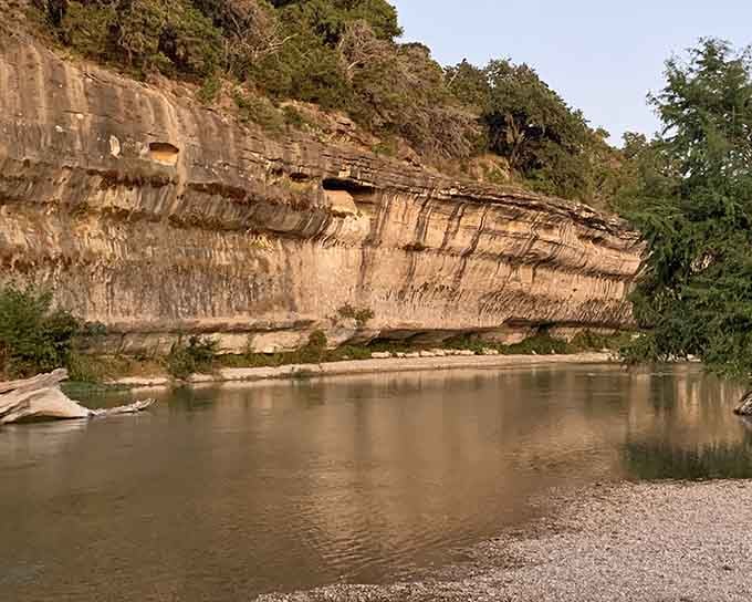 Layered limestone bluffs rise straight from the river's edge, each horizontal stripe a chapter in a very long story.