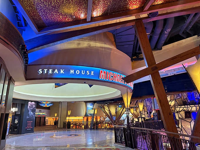 Soaring wooden beams, vivid blue lighting, and a curved marquee sign make this steak house entrance feel genuinely championship-worthy.