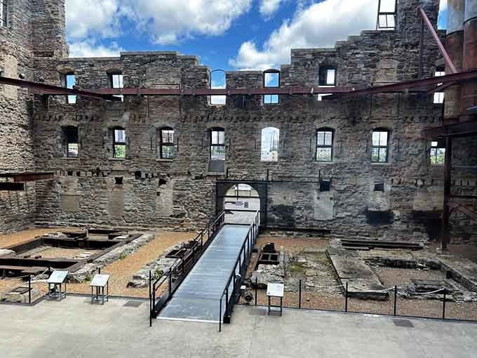 Rugged limestone walls rise around the old mill floor, where informational signs now stand where thundering machinery once shook the ground.