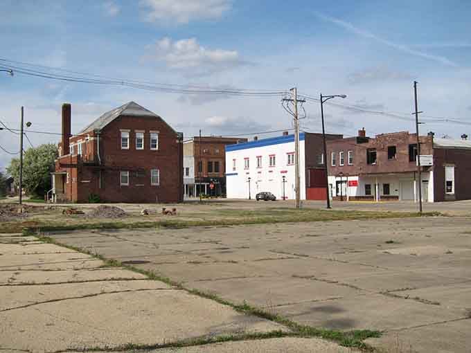 Weathered brick buildings face an open lot in Rantoul, where wide skies and open space tell a story of quiet resilience.