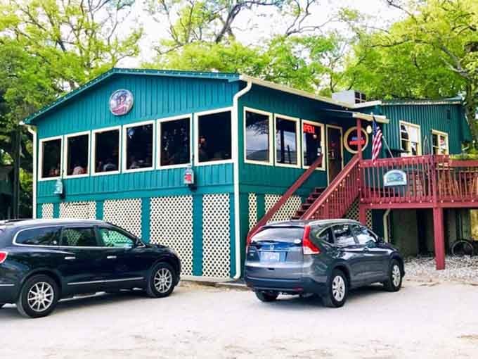 Bright green summer leaves frame this teal two-story charmer, making it look like the happiest seafood secret in Murrells Inlet.