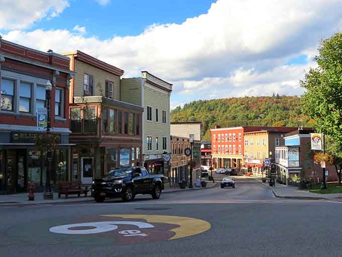 Mountains frame these colorful buildings like nature's own picture frame, with fall foliage adding the perfect finishing touch.