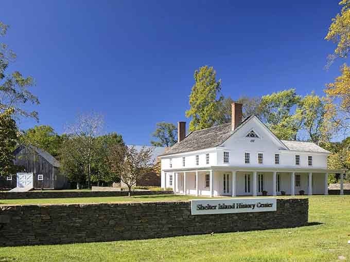 The pristine white colonial building sits peacefully on manicured grounds, preserving history with grace and quiet dignity.