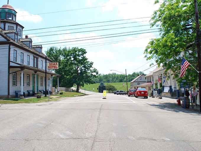The Zoar Hotel sign hangs quietly beside rolling green hills, welcoming visitors to a village where time moves at its own pace.