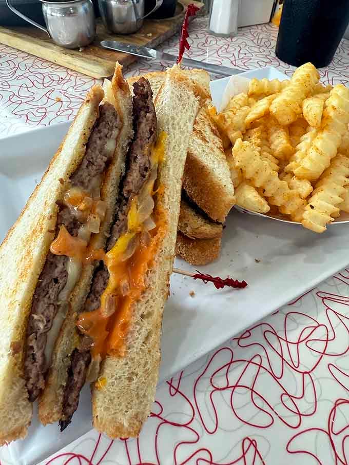 Peggy Sue's Patty Melt sliced clean in half, cheese melting everywhere. This sandwich has absolutely no regrets whatsoever.