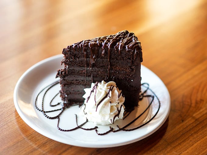 Towering chocolate cake with whipped cream that looks like it could end arguments and start very happy food comas immediately.