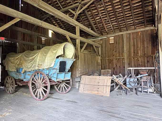 That blue covered wagon sitting inside the barn looks like it took a wrong turn from an old Western film.