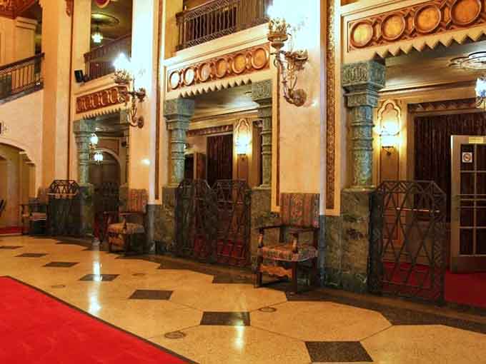 Ornate columns, decorative ironwork gates, and vintage chairs lining the lobby corridor, because even the waiting area deserves to be spectacular.