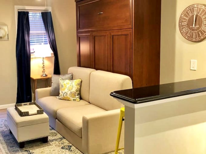 The living room says "settle in," and honestly, that Murphy bed cabinet is furniture doing double duty magnificently.