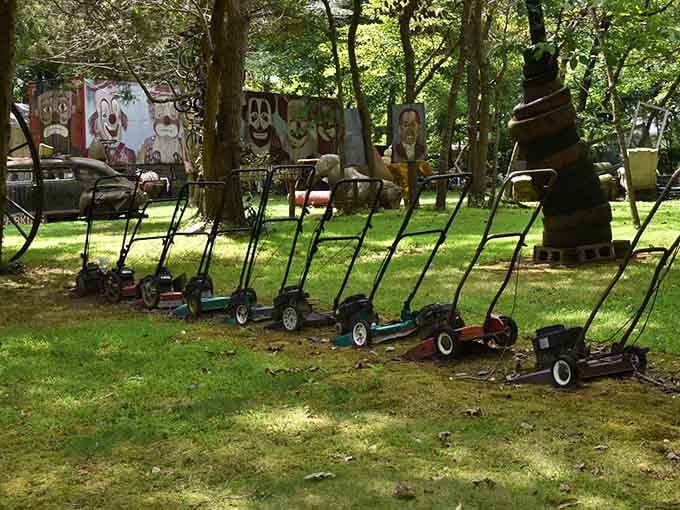 A perfectly lined row of vintage lawnmowers standing at attention, which is either folk art or the world's most organized yard sale.
