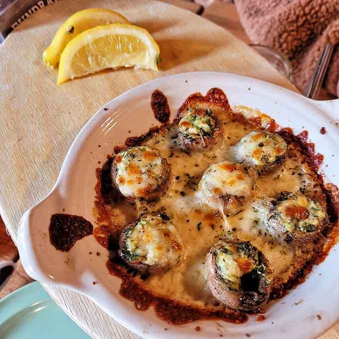 Stuffed mushrooms baked in bubbling cheese and served with lemon. A starter that quietly steals the whole show.