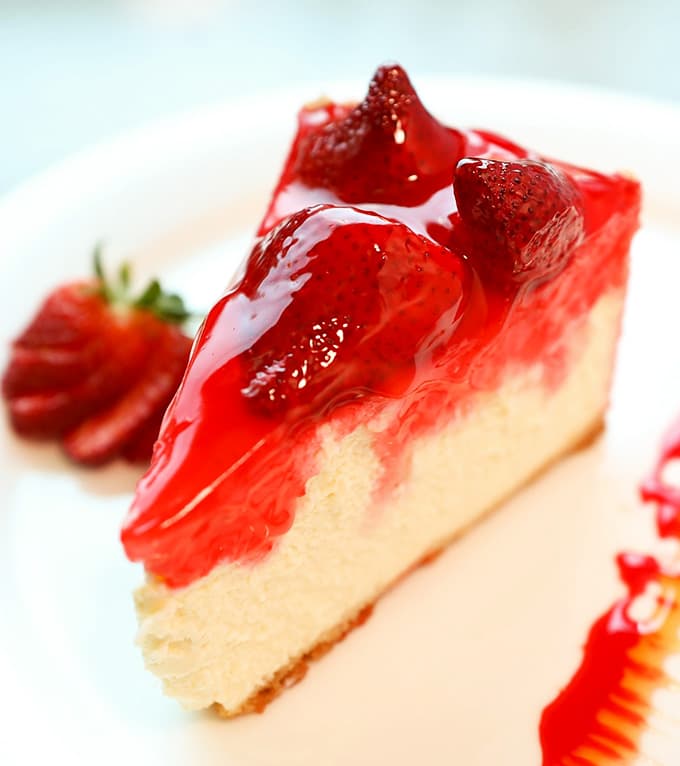Strawberry cheesecake so glossy and generous it looks like it was styled for a magazine cover shoot.