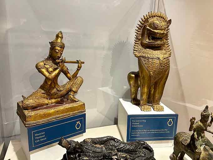 A gilt-metal musician and a gilded Foo Lion from Thailand, proving that great art travels remarkably well.