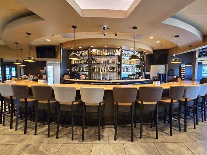 A full, well-stocked bar with a curved counter that practically invites you to pull up a seat and stay awhile.