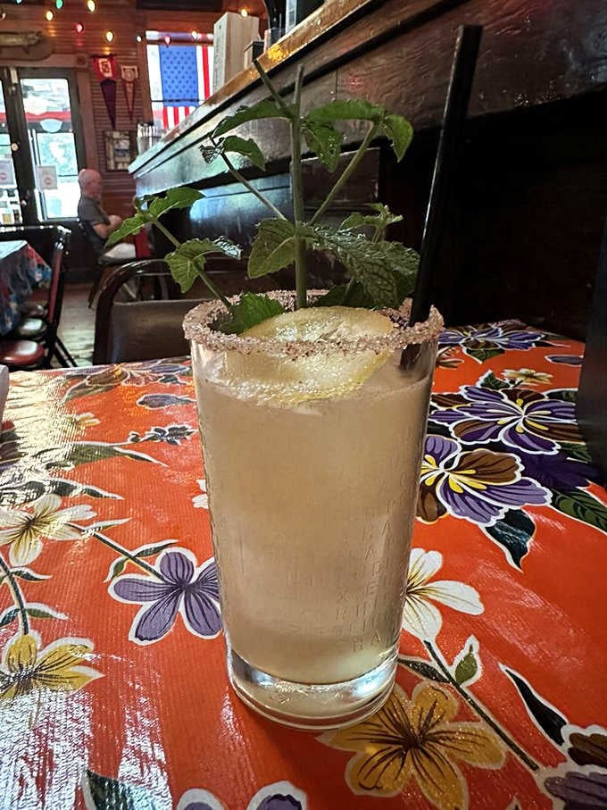 Fresh mint, a sugared rim, and good company nearby. This drink understands the assignment completely.