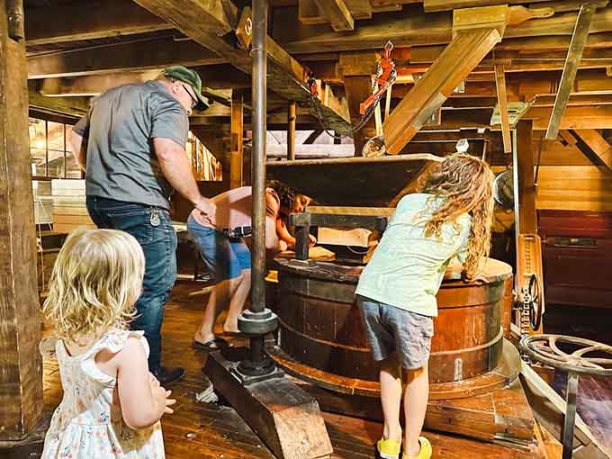 Kids leaning into a working grist mill, wide-eyed and curious. This is what a real field trip looks like.