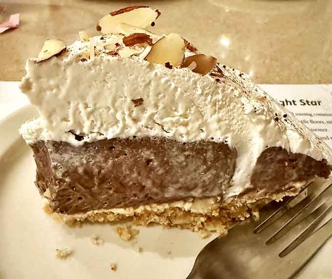A towering slice of chocolate cream pie topped with whipped cream and toasted almonds, dessert doesn't get more serious than this.