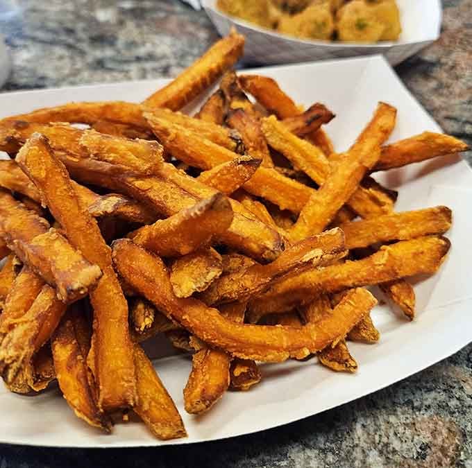A mountain of crispy sweet potato fries so golden and gorgeous, even your diet is reconsidering its life choices right now.