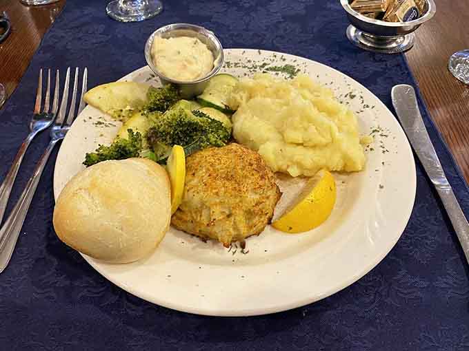 That golden crab cake with fluffy roll and perfectly cooked vegetables represents everything Maryland does right on one beautiful plate.