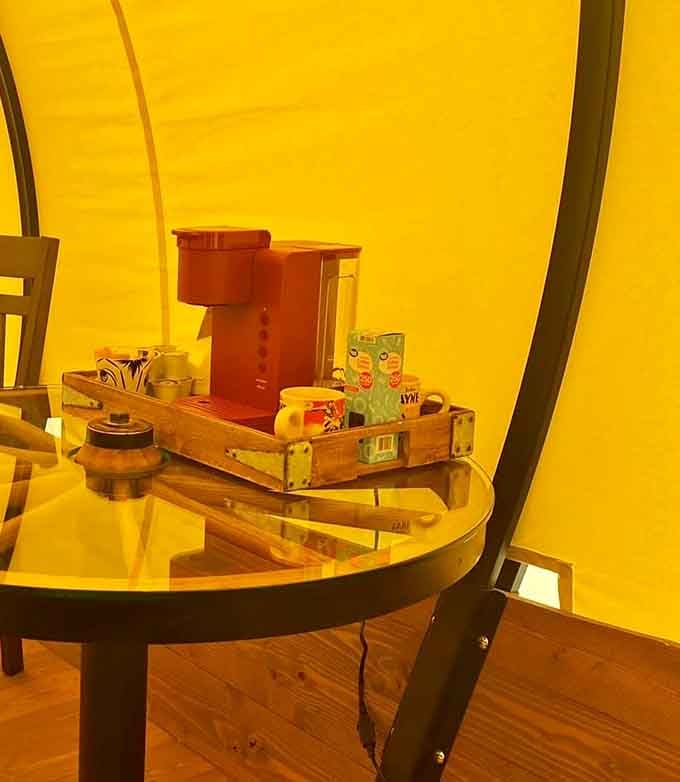 A coffee maker sitting on a wagon wheel table. The pioneers would have wept with envy.