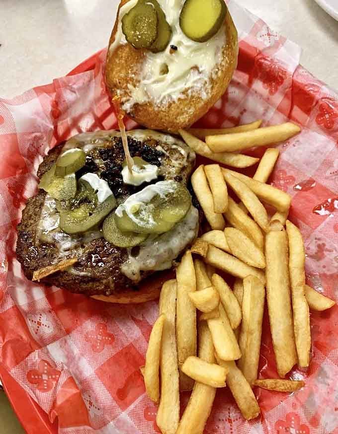 A proper burger with pickles, melted cheese, and fries, the kind that makes you forget everything else.