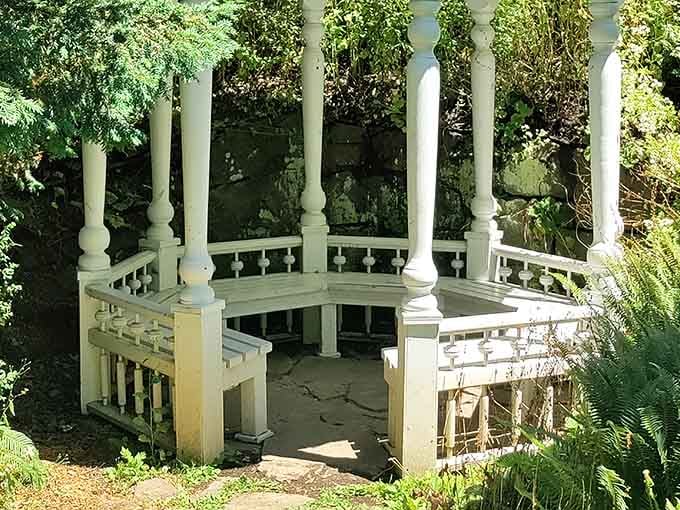 A white columned gazebo tucked into the greenery, quietly waiting for someone to sit and stay awhile.