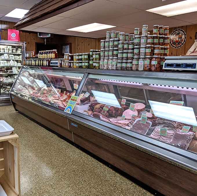 Rows of cured meats beneath jars stacked to the ceiling — this display case deserves its own zip code.