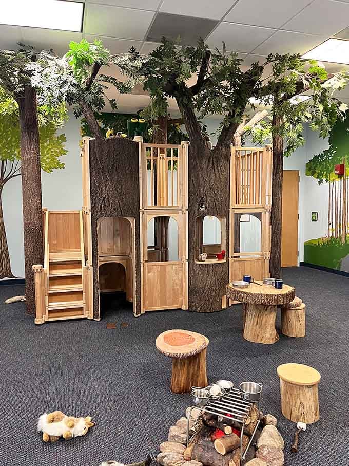 An indoor treehouse surrounded by towering sculpted trees and a pretend campfire is basically every childhood dream made wonderfully real.