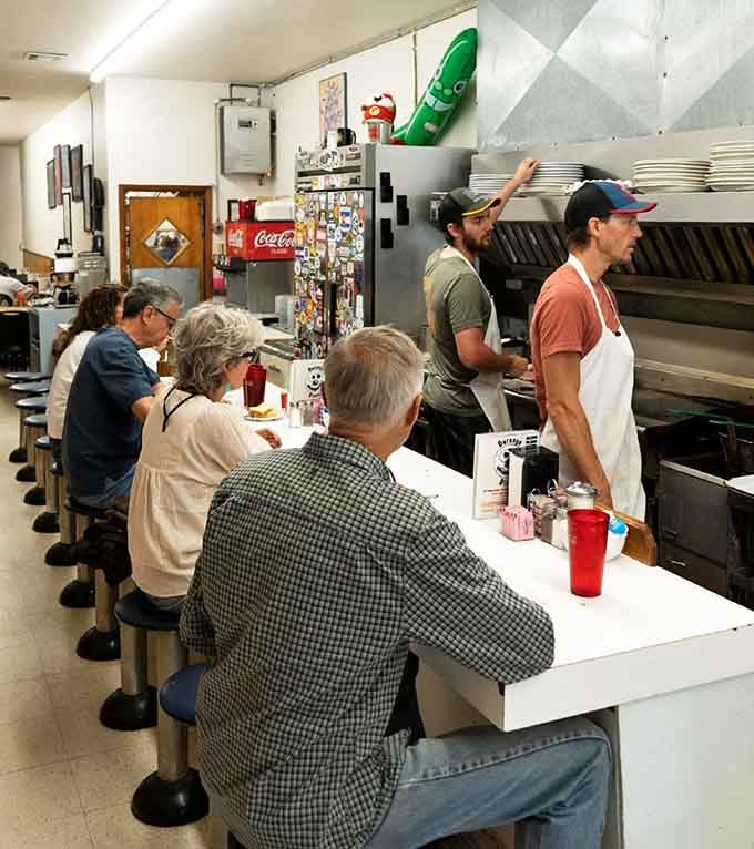 Two cooks moving with quiet confidence behind the counter while regulars lean in, this is the rhythm of a place that knows itself.