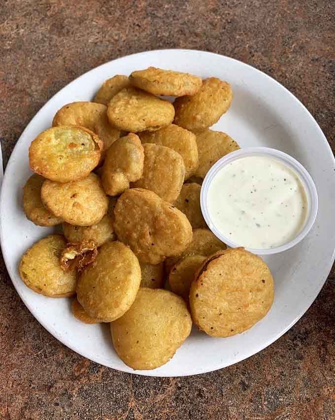 Deep-fried pickles arrive golden and crispy, proving that sometimes the best ideas come from the South's playbook.