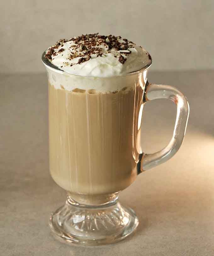 Whipped cream, chocolate shavings, and a warm mug. This Irish coffee is basically a hug you can sip.