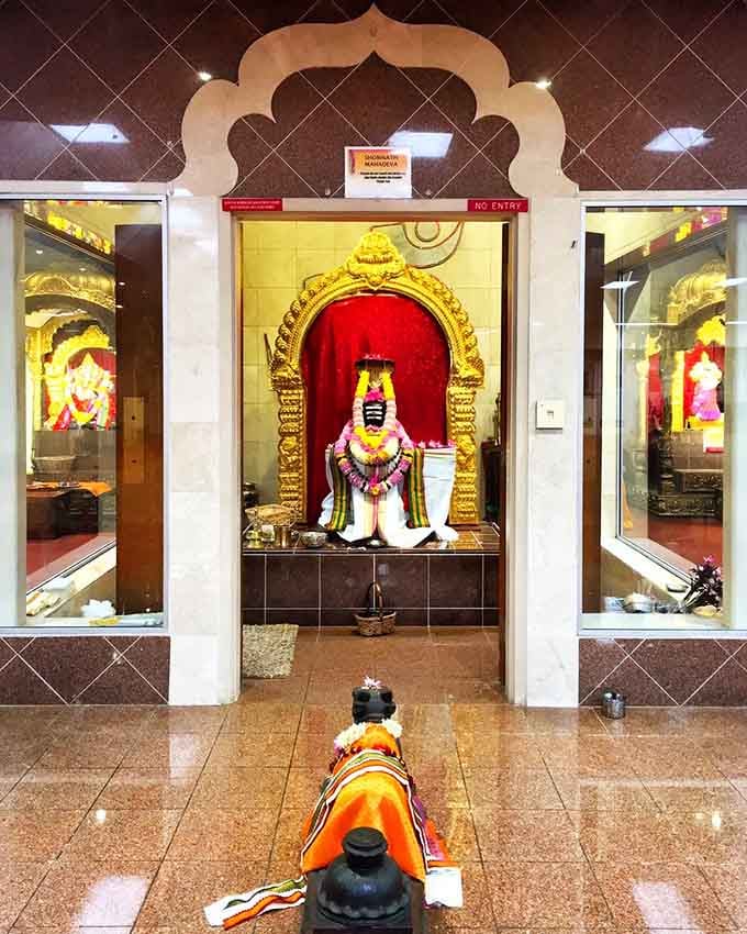 Shonnath Mahadeva sits serenely behind an ornate golden arch, a moment of stillness in a world that rarely slows down.