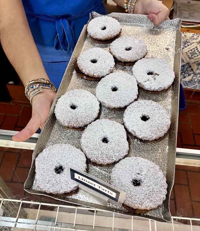 Linzer tarts dusted with powdered sugar, looking like edible snowflakes that actually taste better than they look.