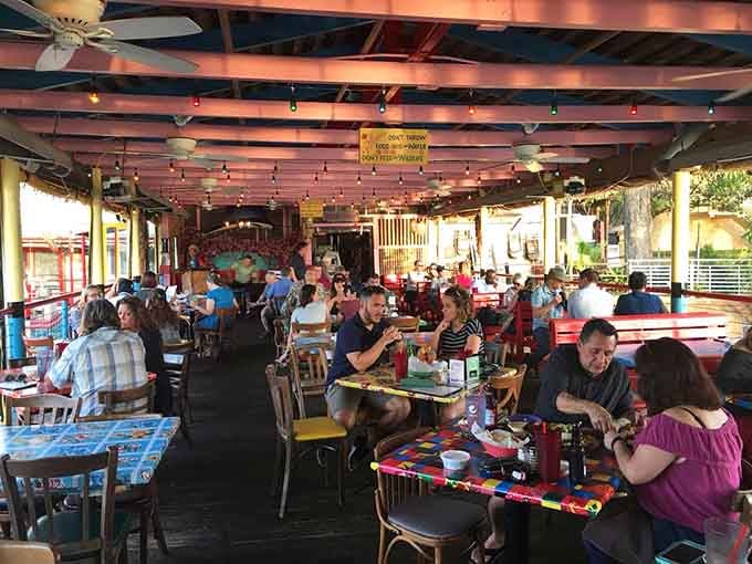 A full deck of happy diners under string lights, proof that good food brings absolutely everyone to the table.